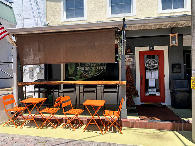 The bright orange outdoor seating at The Salted Fry beckons like a potato-loving friend, promising crispy delights behind that cheerful red door in downtown Mount Dora.