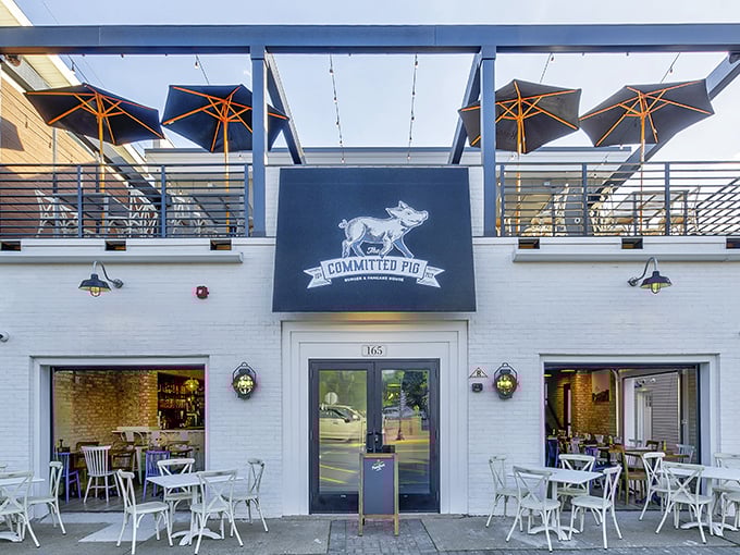 The Committed Pig's charming white exterior with rooftop dining is like finding the VIP section of Jersey Shore dining—complete with American flag and umbrellas for those who prefer shade with their indulgence.