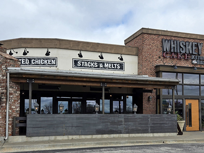 Rustic brick meets modern charm at Whiskey Cake's inviting exterior. The patio planters hint at the farm-to-table philosophy waiting inside.