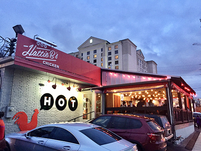 The iconic red glow of Hattie B's beckons hungry pilgrims like a Nashville neon lighthouse. Even at dusk, the line forms for that crispy, spicy salvation. 