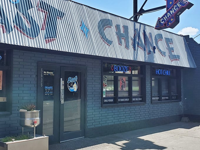 The neon-lit promise of "Slim's Last Chance" beckons like a honky-tonk mirage in Seattle's industrial landscape. Cold beer awaits inside this unassuming chili paradise.