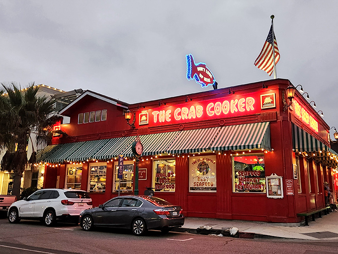 The iconic crimson exterior of The Crab Cooker, with its cheeky "DON'T LOOK UP HERE" fish sign, stands as Newport Beach's delicious rebellion against pretension.