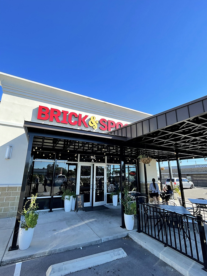 The red signage of Brick & Spoon gleams like a beacon for breakfast lovers. The patio beckons with promise of morning feasts and mimosa-fueled conversations.