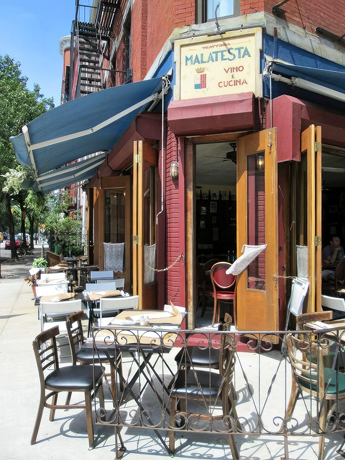 The corner where pasta dreams come true. Malatesta's weathered sign and rustic wooden windows promise authentic Italian comfort without pretension.
