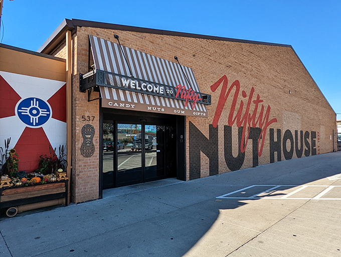 The brick facade of Nifty Nut House beckons like a siren song to sugar enthusiasts. That red script logo promises sweet adventures within.