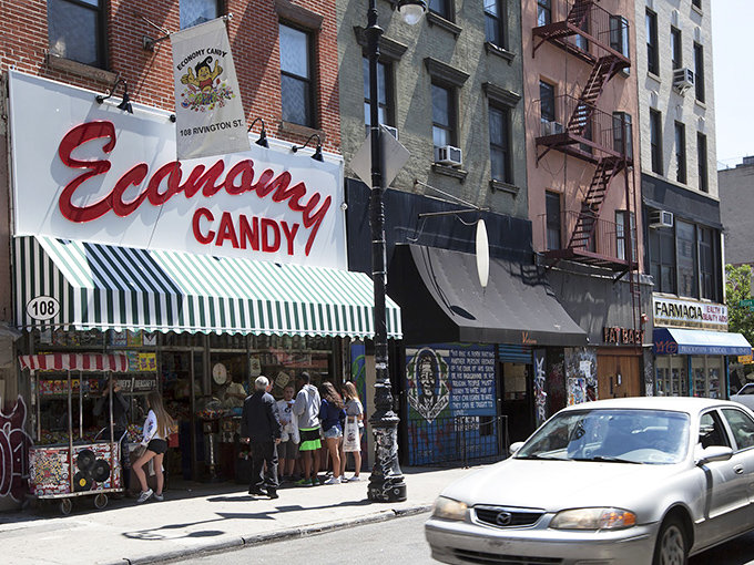 The iconic red cursive sign of Economy Candy beckons sugar-seekers like a lighthouse for sweet-toothed sailors navigating the Lower East Side.