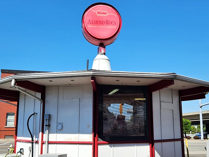 The iconic pink Almond Roca sign stands like a beacon of sweetness against the blue Tacoma sky, promising delicious treasures within.