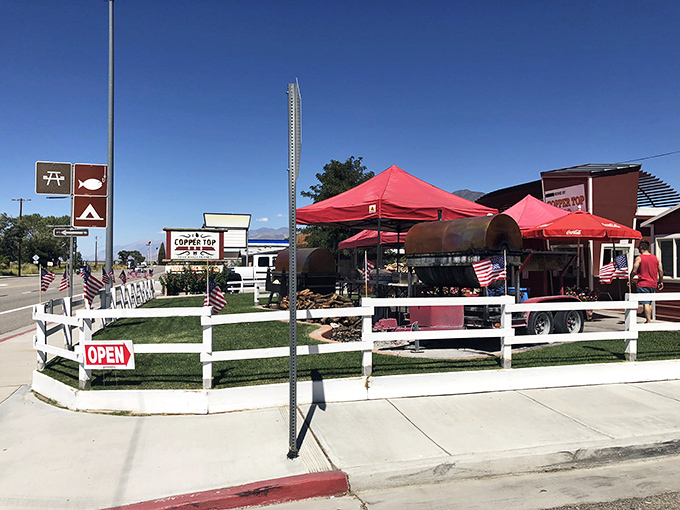 The iconic red barn-like exterior of Copper Top BBQ, where those massive smokers out front aren't just for show—they're the source of that heavenly aroma that hits you from a quarter-mile away.