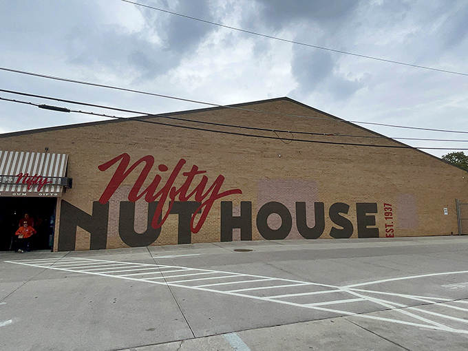 The brick facade of Nifty Nut House beckons like a siren song to sugar enthusiasts. That red script logo promises sweet adventures within.