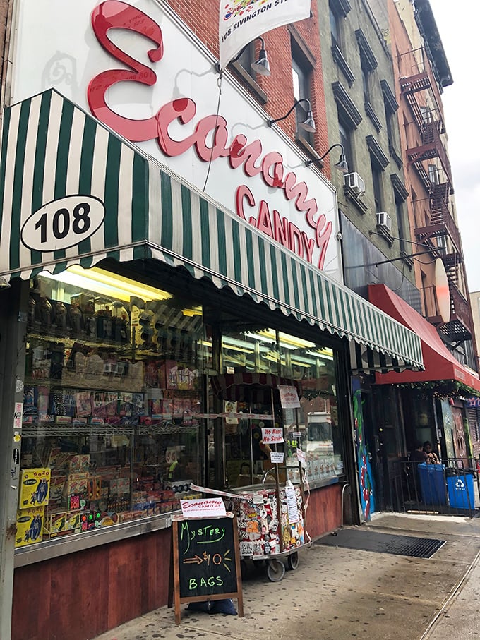 The iconic red cursive sign of Economy Candy beckons sugar-seekers like a lighthouse for sweet-toothed sailors navigating the Lower East Side.