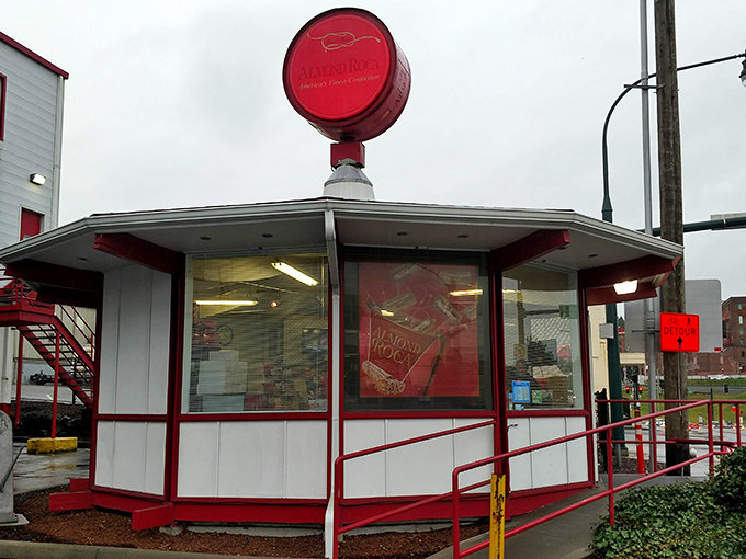 The iconic pink Almond Roca sign stands like a beacon of sweetness against the blue Tacoma sky, promising delicious treasures within.