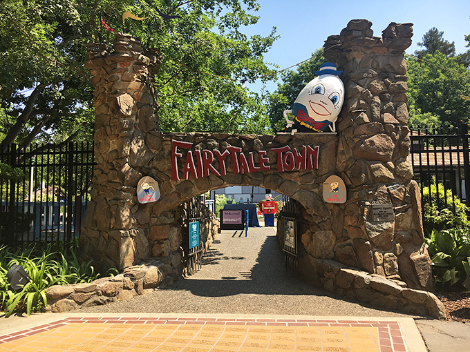The stone archway entrance to Fairytale Town welcomes visitors with Humpty Dumpty perched above, proving some falls can lead to happy endings after all.