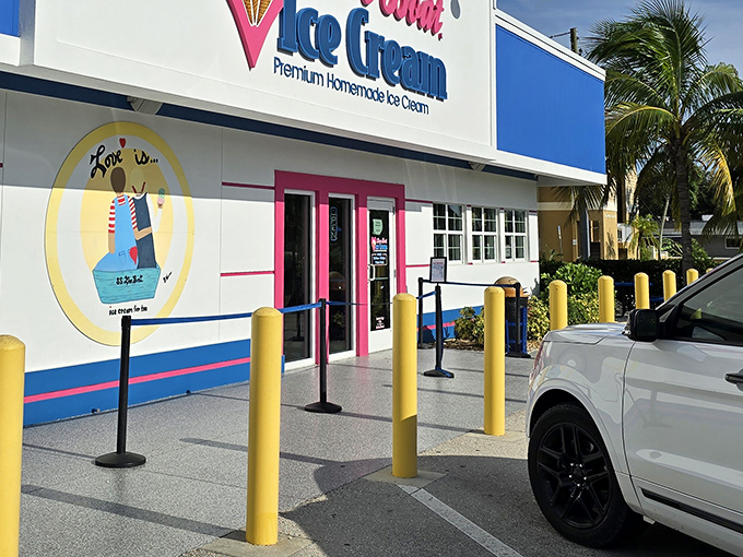 The bright blue and pink exterior of Love Boat Ice Cream stands out like a tropical oasis in the Florida heat, complete with a whimsical boat logo that promises sweet adventures ahead.