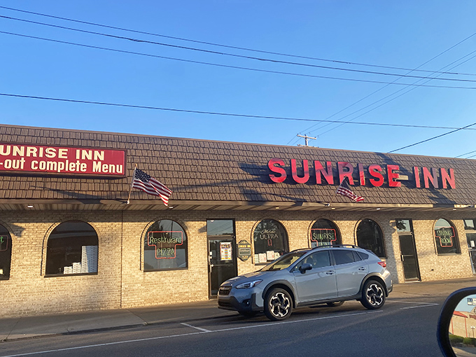 The unassuming exterior of Sunrise Inn hides culinary treasures within, like finding a Picasso at a yard sale. Those red letters promise pizza paradise.