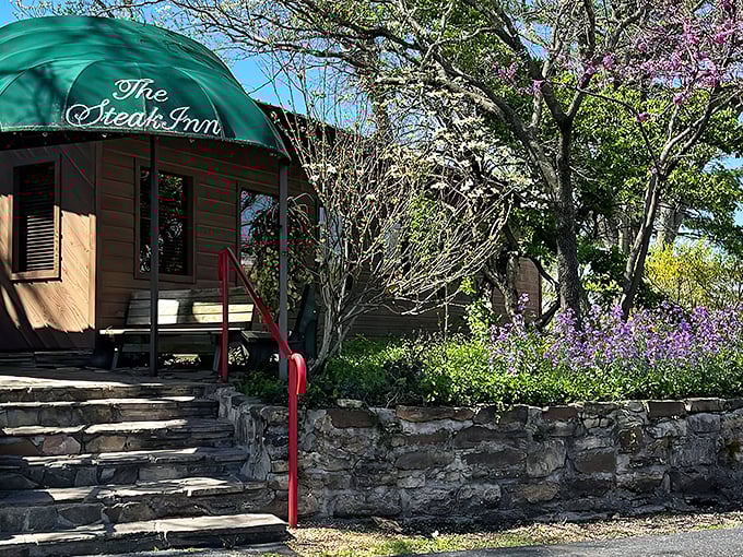 The iconic green awning and red railings of The Steak Inn welcome hungry travelers like a beacon in the Ozark wilderness.