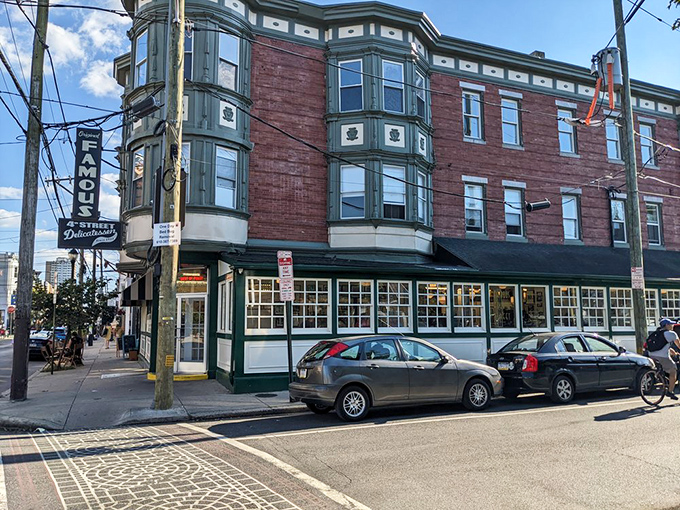 The iconic brick corner building housing Famous 4th Street Delicatessen stands like a time capsule in Philadelphia's Queen Village. Green-trimmed windows hint at the culinary treasures within.