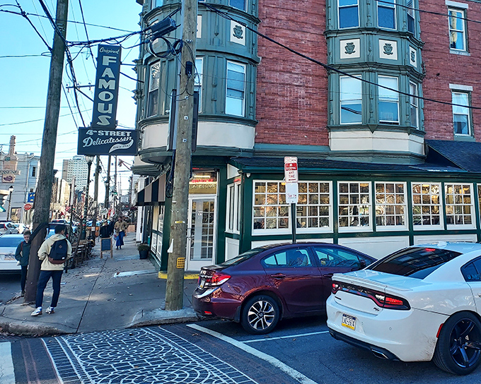 The iconic green-trimmed corner building of Famous 4th Street Delicatessen stands as a beacon of culinary tradition in Philadelphia's Queen Village neighborhood.