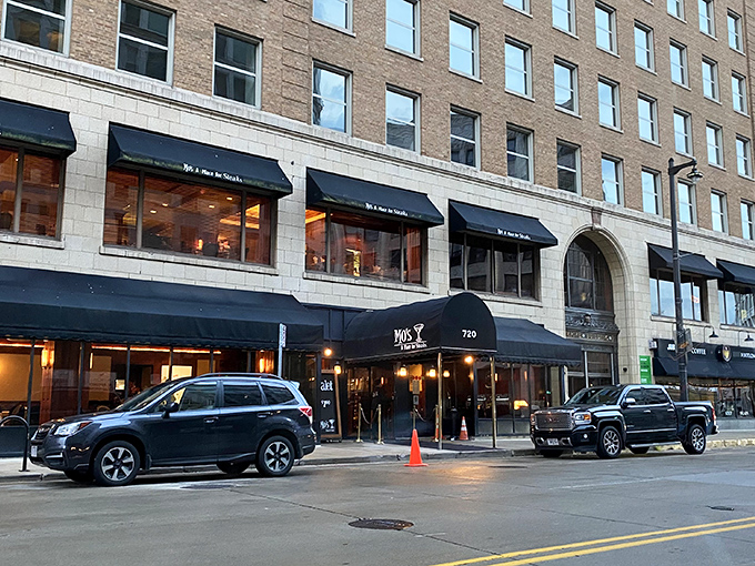 The classic black awnings of Mo's stand like elegant sentinels on Milwaukee's Plankinton Avenue, promising culinary adventures within these historic brick walls.