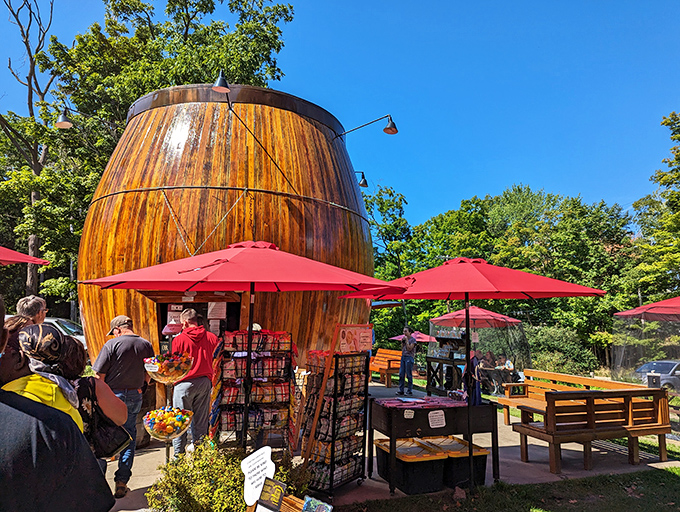 The Douglas Root Beer Barrel stands like a wooden monument to summer nostalgia, its rich amber planks gleaming in the Michigan sunshine.