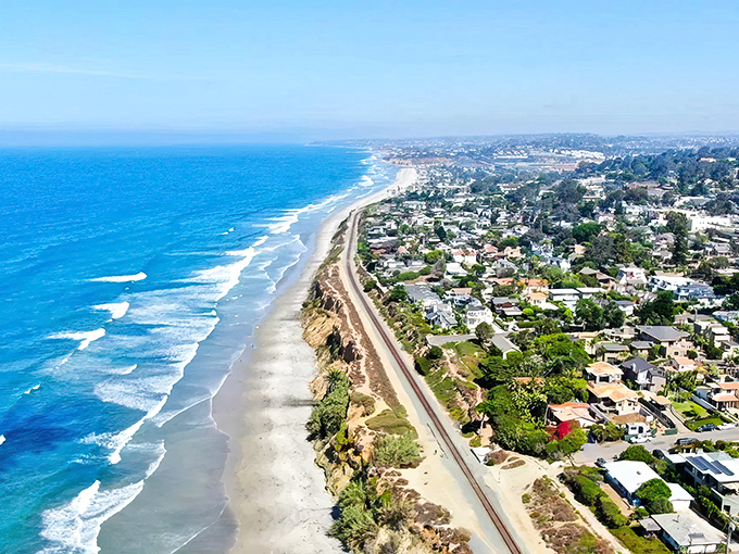 Del Mar's coastline stretches like nature's own masterpiece, where golden beaches meet residential charm. The ultimate California dream captured in one breathtaking aerial view.