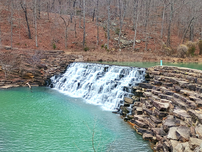 Nature's perfect postcard moment: a rustic wooden bridge leads you between cascading waterfalls, promising adventure with every step into this emerald paradise.