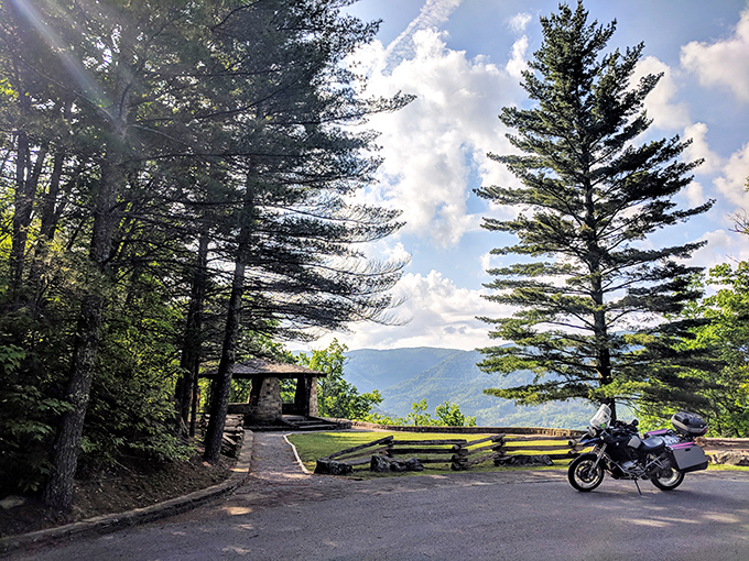 Stone pillars frame nature's masterpiece at Kingdom Come's overlook. The Appalachian Mountains roll away like waves frozen in time, a sight worth every step of the climb. 