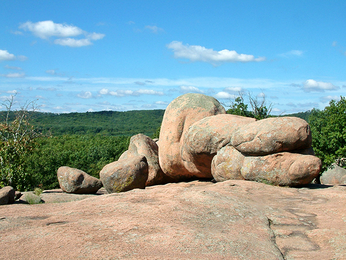 Nature's sculpture garden spans the horizon, where billion-year-old pink granite boulders rest like gentle giants against Missouri's emerald landscape.