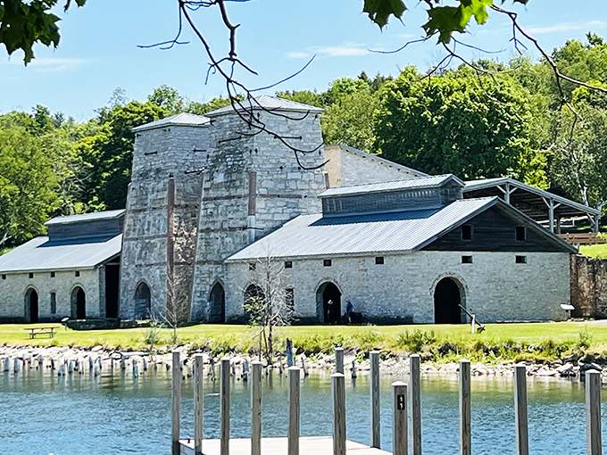 The imposing limestone blast furnaces stand like ancient temples against the azure waters of Snail Shell Harbor, a perfect marriage of industrial history and natural beauty.