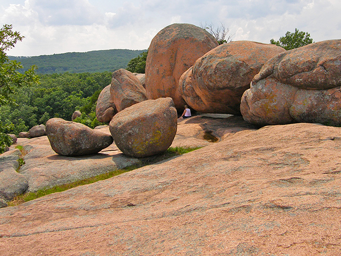 Nature's sculpture garden spans the horizon, where billion-year-old pink granite boulders rest like gentle giants against Missouri's emerald landscape.