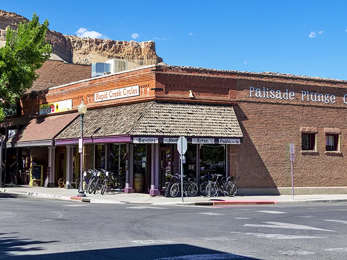 Main Street Palisade stretches toward dramatic Book Cliffs, where small-town charm meets geological grandeur in perfect Western Slope harmony.
