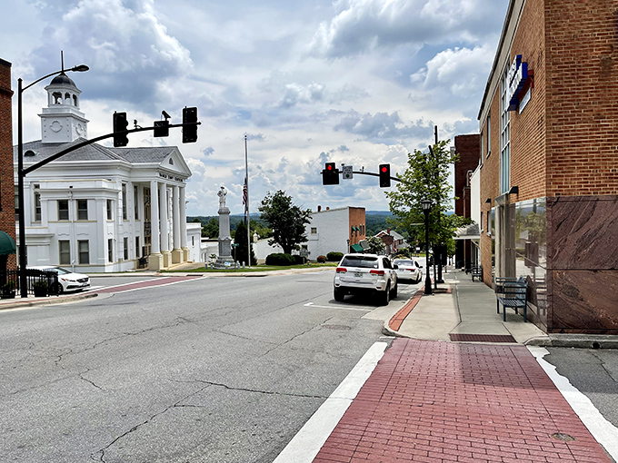 Quaint brick sidewalks and historic white architecture greet you as you explore this charming downtown street under a soft, cloudy sky.
