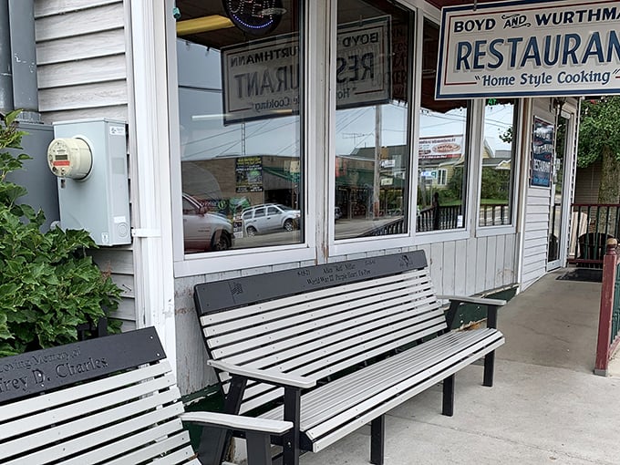 The unassuming exterior of Boyd & Wurthmann Restaurant, where that weathered bench has heard more food stories than most food critics. Culinary treasures await inside.