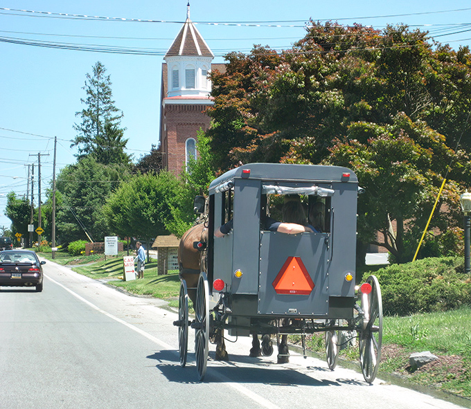 The classic Amish buggy against a church backdrop isn't just transportation—it's a moving postcard of a simpler time that somehow feels right at home in 2023.