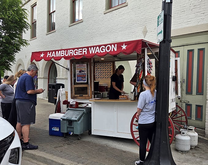 The iconic Hamburger Wagon stands proudly on Miamisburg's Main Street, its red awning and wagon wheels a beacon for burger enthusiasts since 1913. 