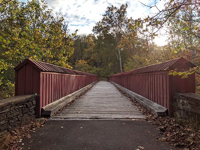 The iconic red-railed bridge at Ralph Stover welcomes hikers like an old friend, promising adventures on the other side of its weathered wooden planks.