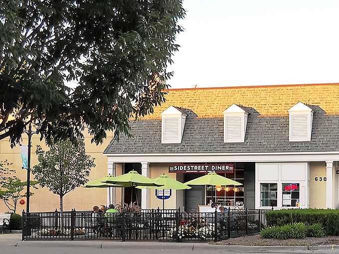 The charming yellow brick exterior of Side Street Diner beckons with its distinctive mansard roof and welcoming entrance. A hidden gem worth seeking out!