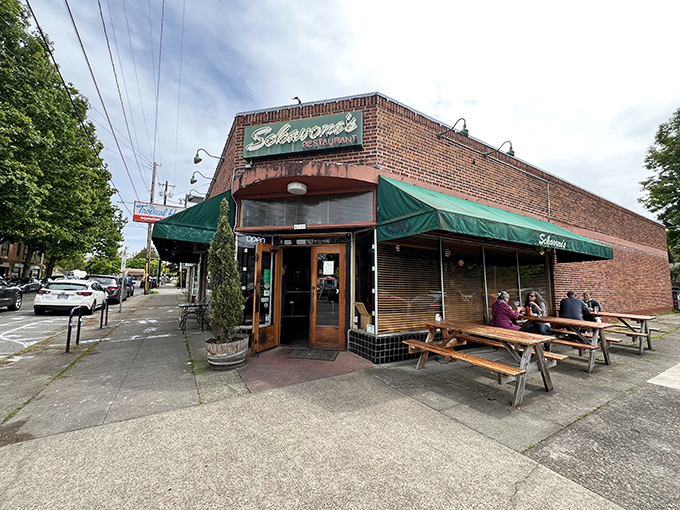 The corner brick building glows like a lighthouse for hungry souls, its green awnings and twinkling lights promising comfort on even the dreariest Portland evening.
