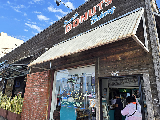 The unassuming facade of Seaside Donuts Bakery hides a world of fried dough magic. That "OPEN 24HRS" sign is the bat signal for donut lovers everywhere.