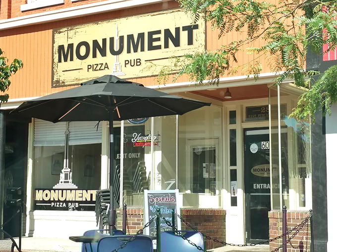 The unassuming storefront of Monument Pizza Pub beckons hungry travelers with its vintage charm and promise of pizza perfection in downtown Angola. 
