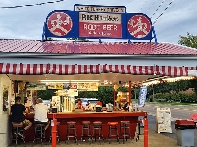The iconic White Turkey Drive-In stands proudly with its red roof and striped awnings, a time capsule of Americana serving happiness on a tray since generations.