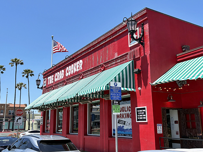 The iconic crimson exterior of The Crab Cooker, with its cheeky "DON'T LOOK UP HERE" fish sign, stands as Newport Beach's delicious rebellion against pretension.