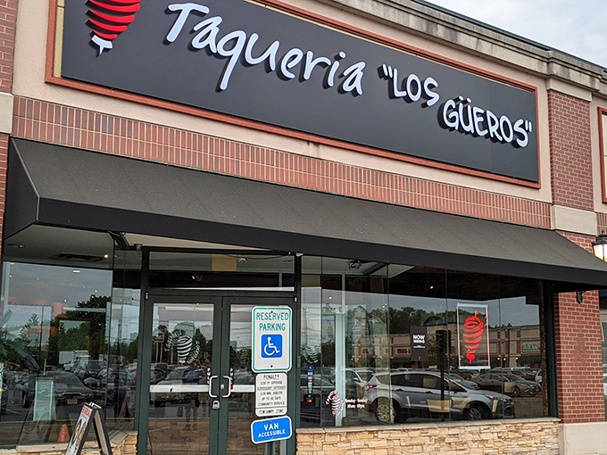The iconic black sign with white lettering and red spiral logo beckons hungry travelers like a lighthouse for those lost in a sea of mediocre Mexican food.