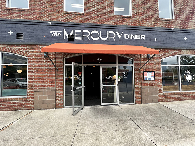 The retro-futuristic facade of The Mercury Diner makes a bold statement with its navy blue paint, orange awning, and playful star accents&mdash;cosmic comfort food awaits inside.