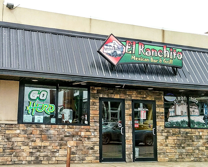 The vibrant storefront of El Ranchito glows like a beacon of culinary promise, its colorful signage and stone facade practically shouting "authentic Mexican food happens here!"