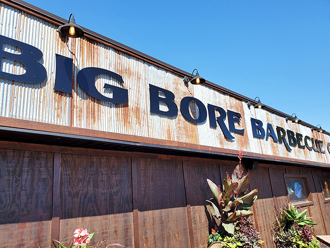 The weathered corrugated metal exterior of Big Bore Barbecue stands as a rustic beacon for meat lovers&mdash;industrial chic meets smokehouse authenticity. 