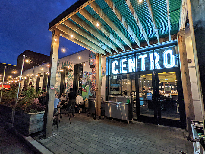 Centro's neon sign glows like a turquoise beacon against the twilight sky, promising Mexican delights in Northeast Minneapolis's urban landscape.