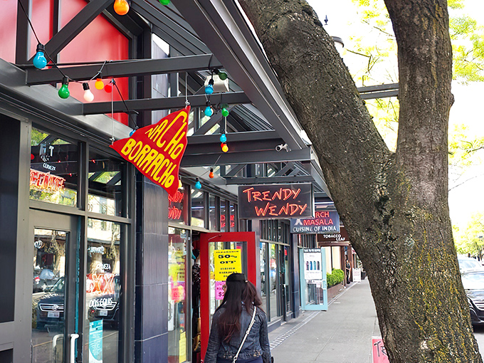 The vibrant triangular sign beckons like a neon North Star for hungry wanderers. Colorful string lights add a festive touch to Broadway's bustling scene.