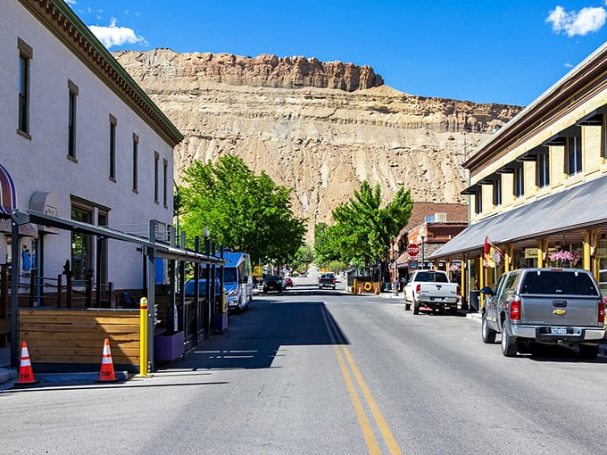 Main Street Palisade stretches toward dramatic Book Cliffs, where small-town charm meets geological grandeur in perfect Western Slope harmony.