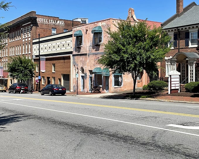 Hotel Lee Land anchors this charming streetscape, where pastel facades and historic brick buildings create a postcard-perfect slice of small-town America.