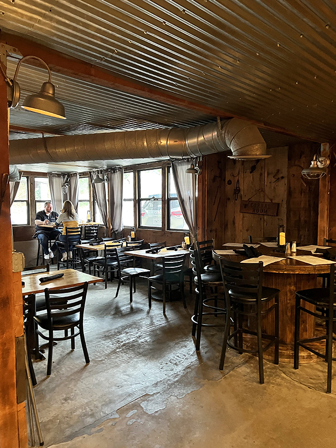 Rustic industrial meets cozy cabin in this dining space. The metal ceiling and exposed ductwork aren't design choices&mdash;they're honest architecture that matches the straightforward food.